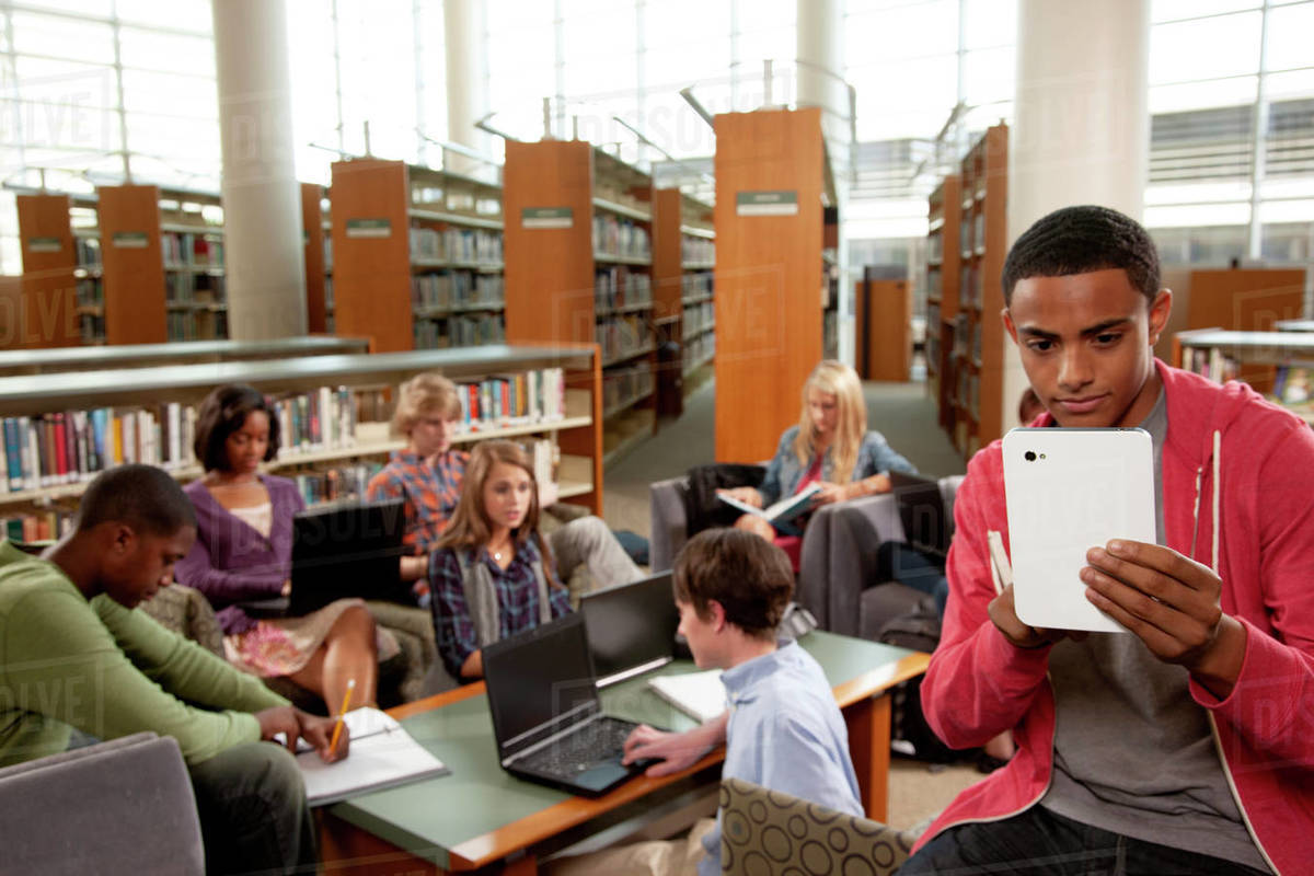 Portrait of confident college students with laptop in library - Stock ...