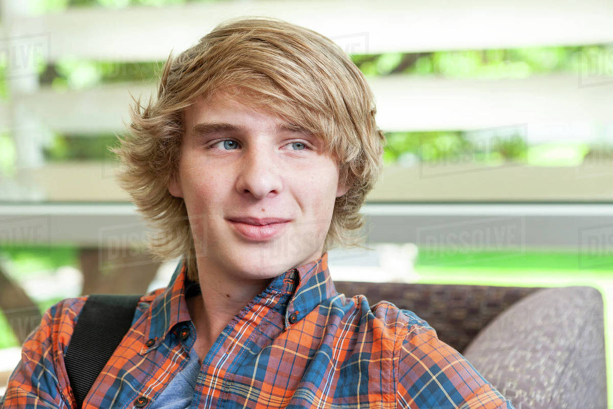 Portrait of male high school student in library. - Stock Photo - Dissolve