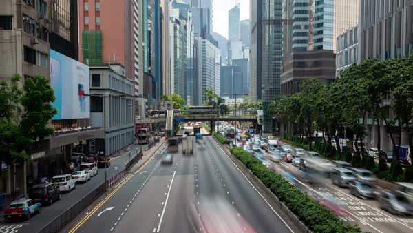 Timelapse cars drive in heavy traffic along Hong Kong wide street ...