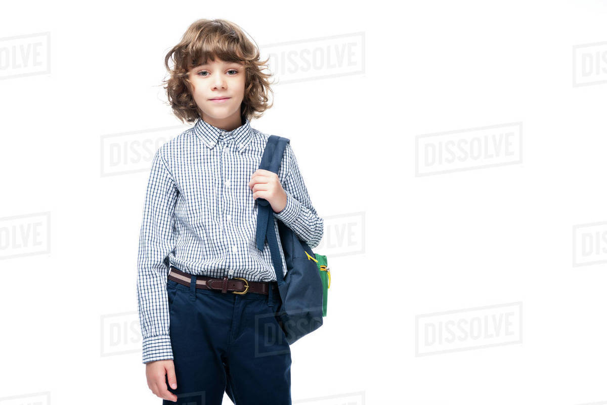 schoolboy holding backpack and looking at camera isolated on white ...