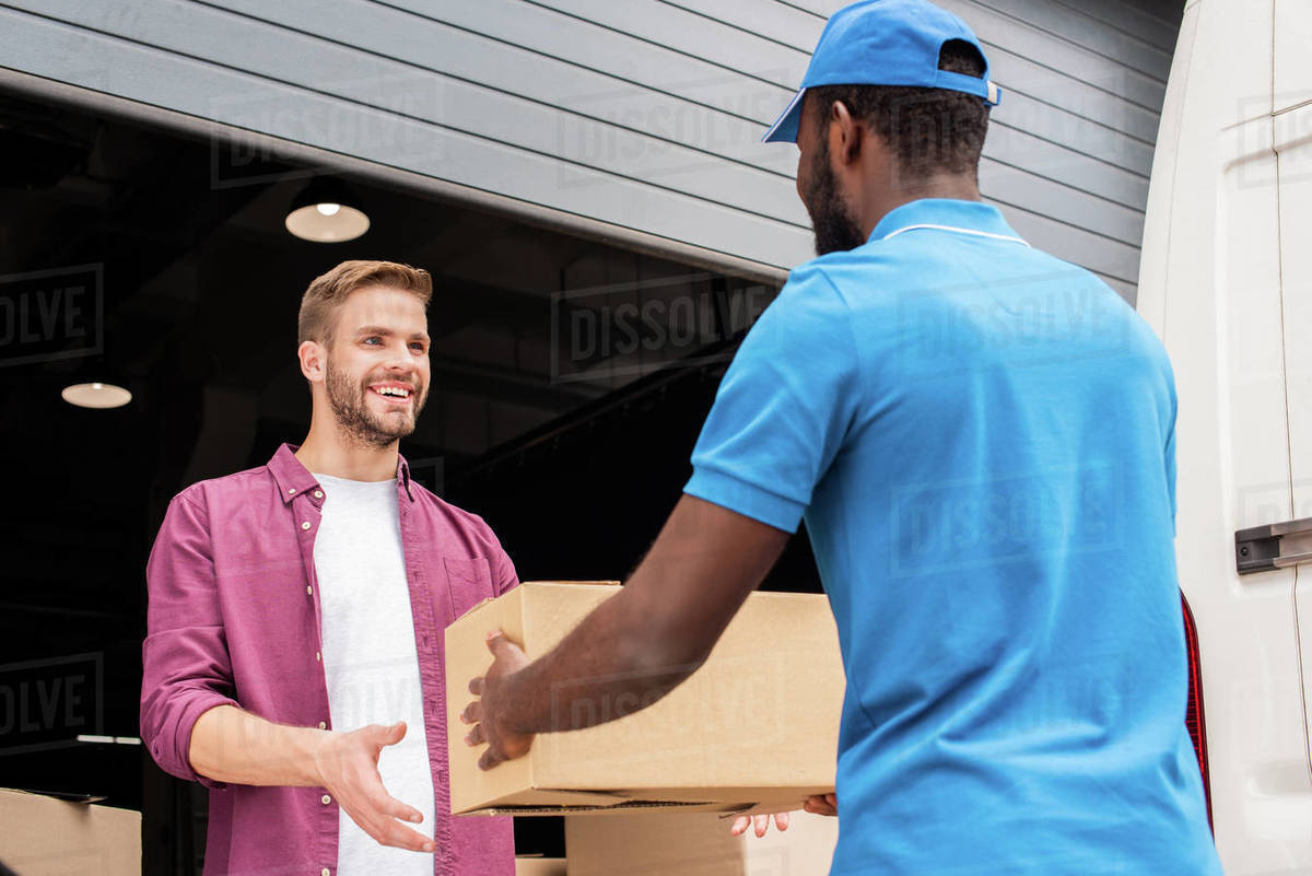african american courier giving delivery box to customer - Stock Photo ...