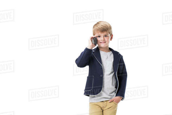 Cute smiling boy talking on smartphone and looking at camera isolated ...