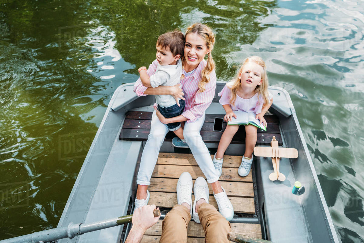 High angle view of beautiful young family riding boat on lake - Royalty ...