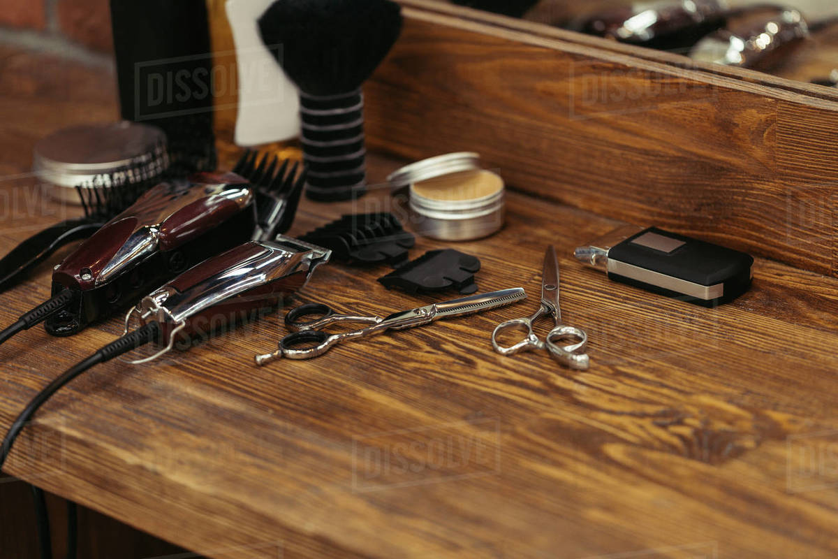 Close-up view of various barber tools on wooden shelf in barbershop ...