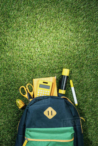 Flat lay with arranged backpack and stationery on green grass - Royalty ...