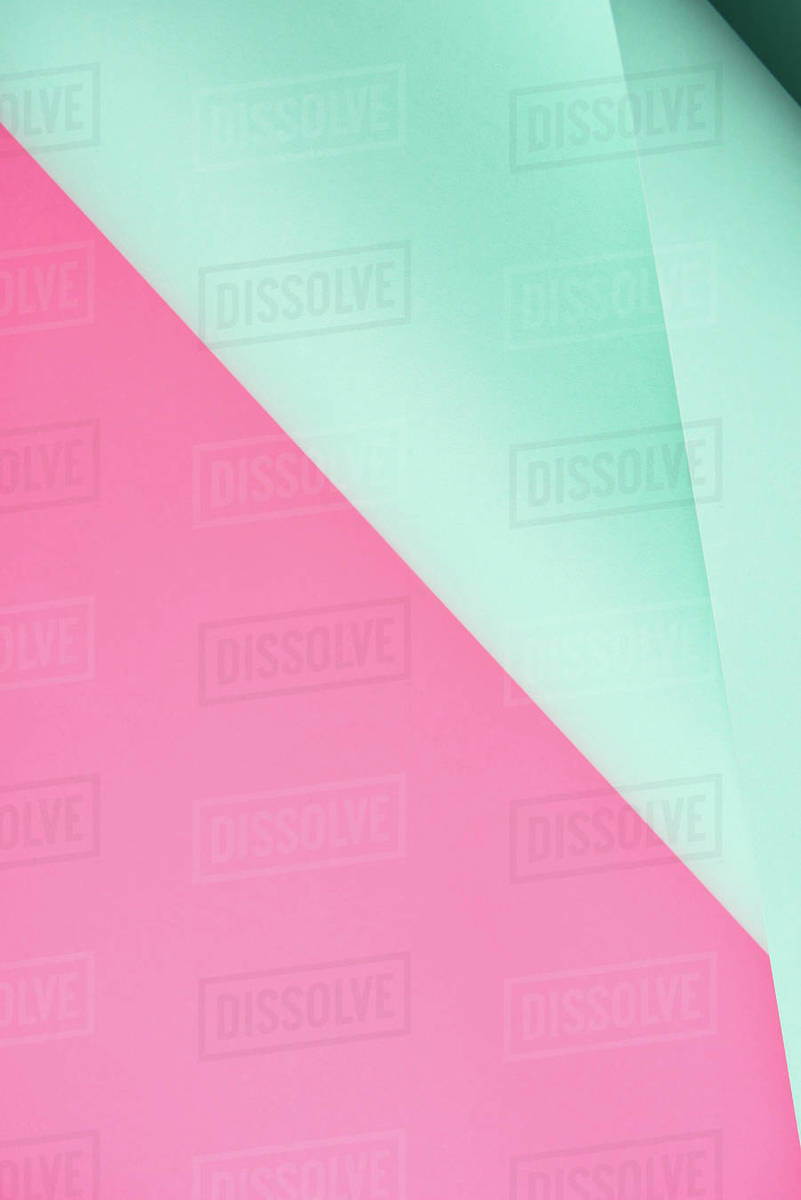 Close-up view of bright turquoise and pink colored paper background ...