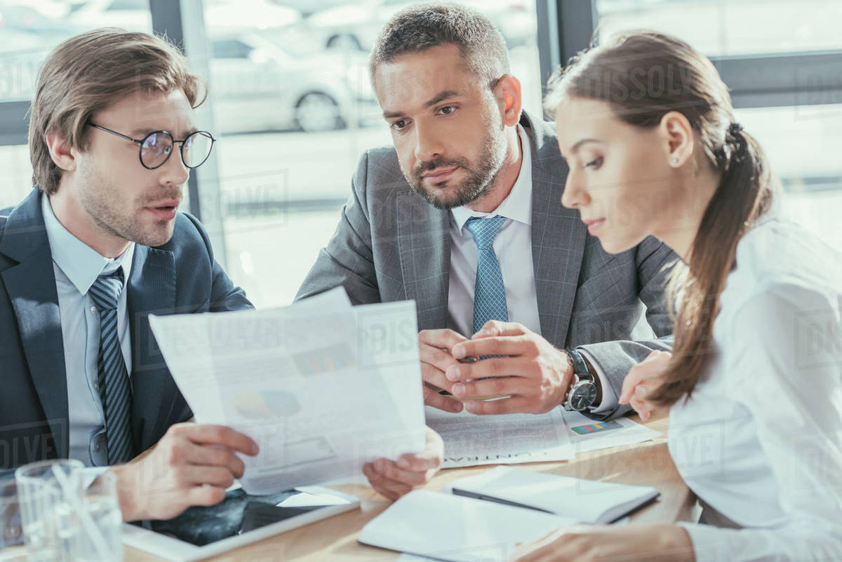 Business people doing paperwork together at modern office - Royalty ...