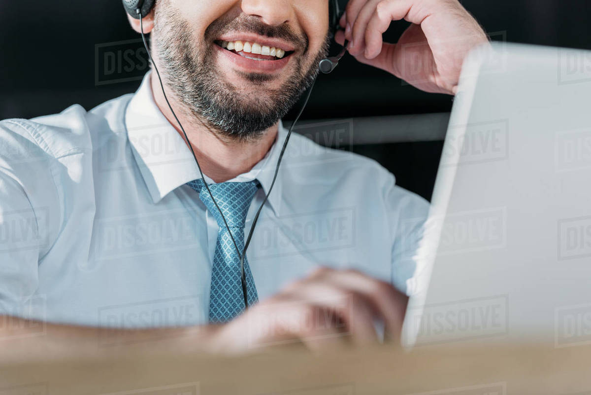 Cropped shot of smiling support hotline worker with laptop and ...