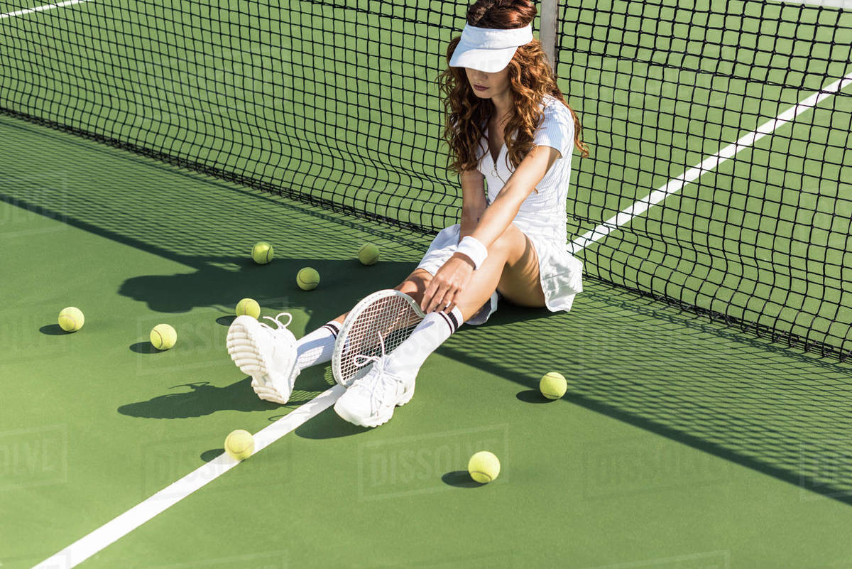 beautiful tennis player in white tennis uniform with racket sitting ...