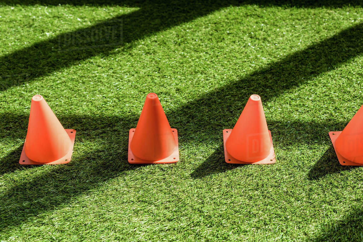 high angle view of row of safety cones standing on grass field ...