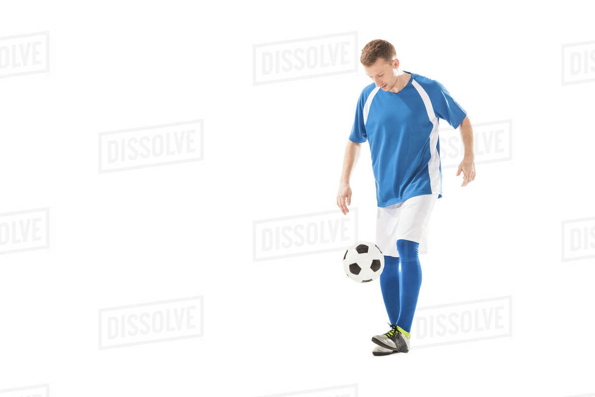 full length view of young sportsman playing with soccer ball isolated ...