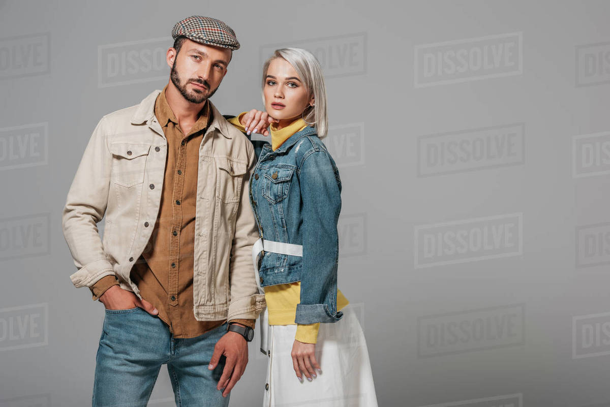 Beautiful couple of models posing in autumn outfit, isolated on grey ...