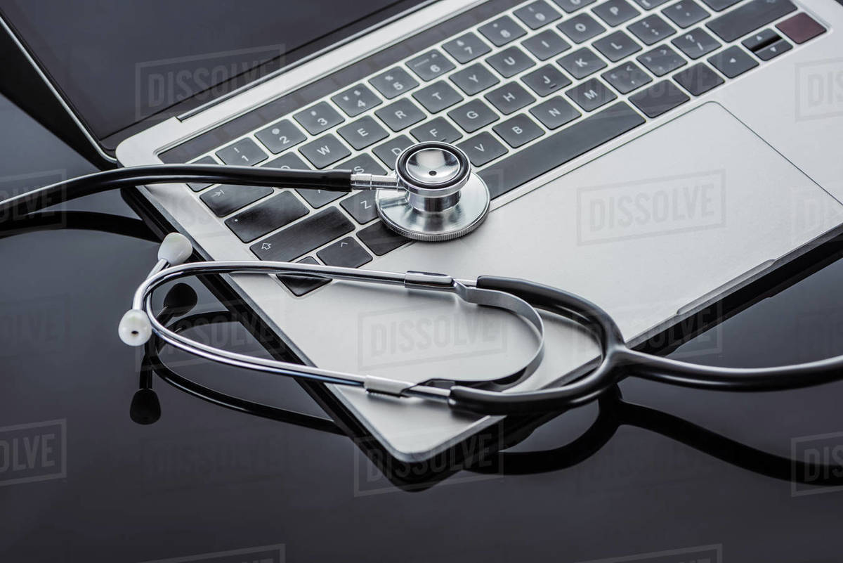 close up view of stethoscope and laptop on glass surface - Royalty-free ...