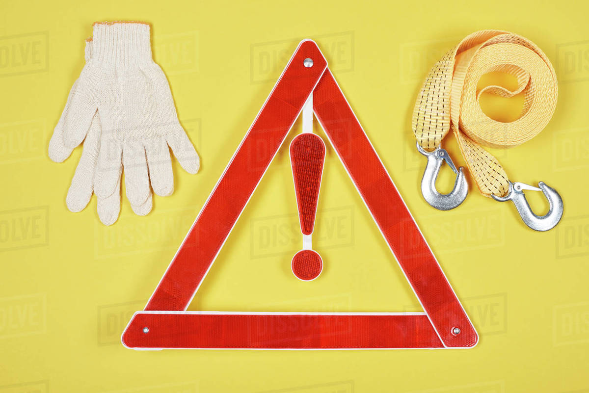 top view of warning triangle road sign, gloves and car tow rope ...
