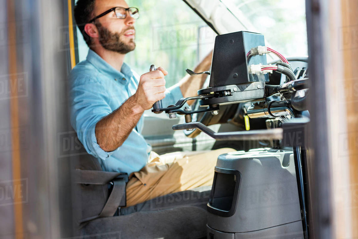 handsome school bus driver losing door with lever and looking at rear ...