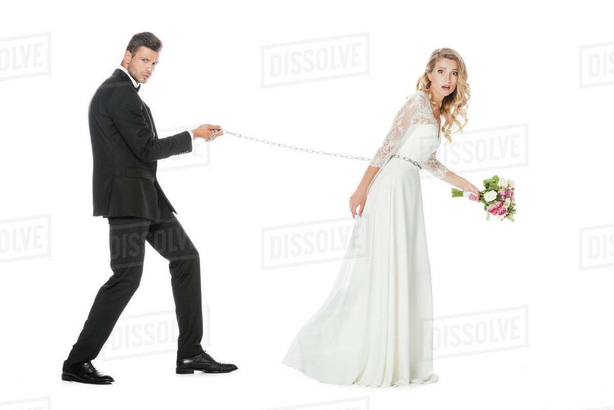 Side view of young groom with chain and leashed shocked bride isolated ...