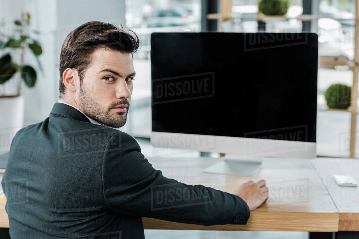 back view of businessman at workplace with computer screen with blank ...