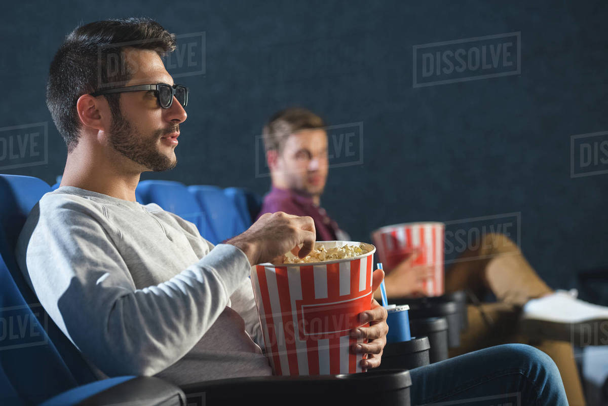 Selective focus of man in 3d glasses with popcorn watching film in ...