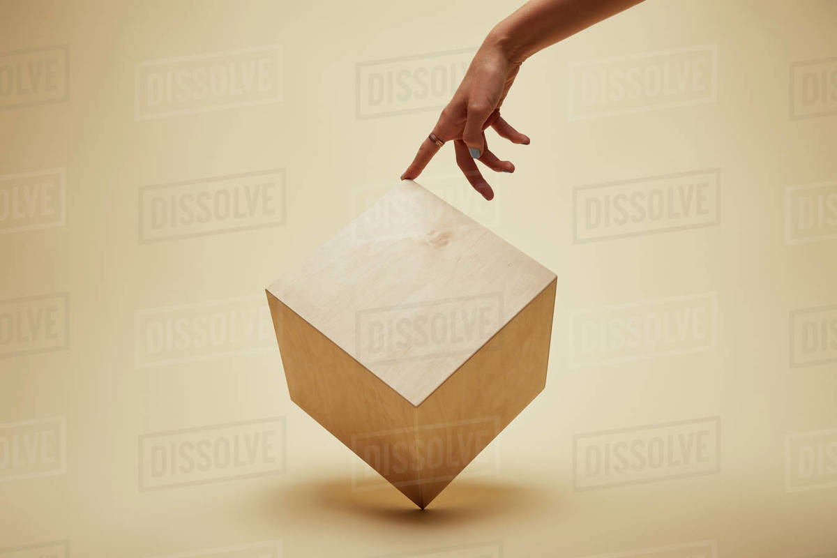 Cropped image of woman touching wooden cube on beige - Royalty-free ...