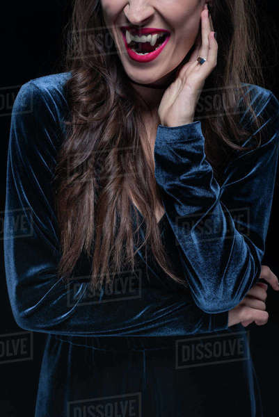 Cropped view of woman showing vampire fangs isolated on black - Royalty ...