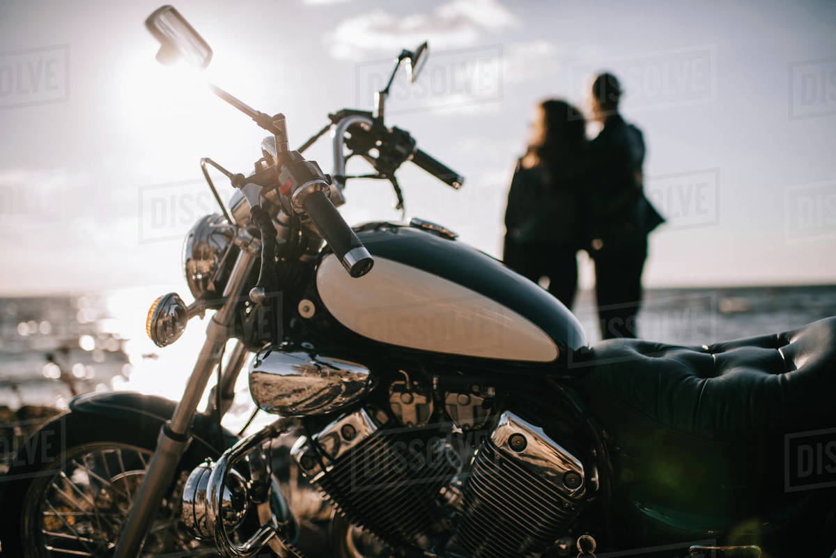 Selective focus of classical chopper motorbike and couple looking at ...