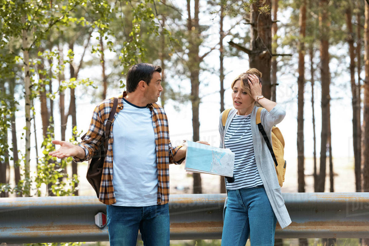Emotional tourists with backpacks and map got lost - Royalty-free Stock ...
