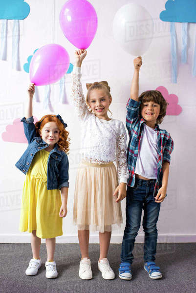 adorable happy kids holding balloons and smiling at camera at birthday ...