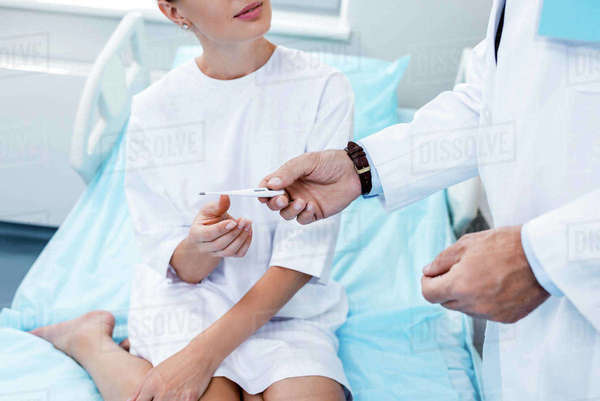 Cropped image of male doctor giving thermometer to female patient in ...