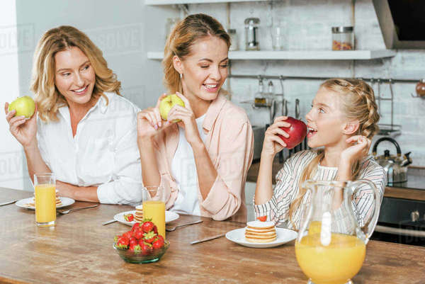 Happy three generations of women with pancakes and healthy apples for ...