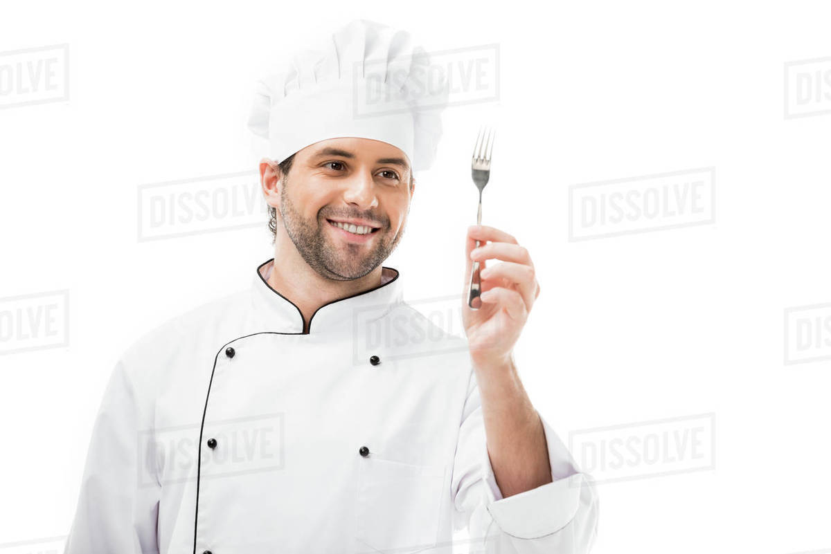Happy young chef holding fork isolated on white - Stock Photo - Dissolve
