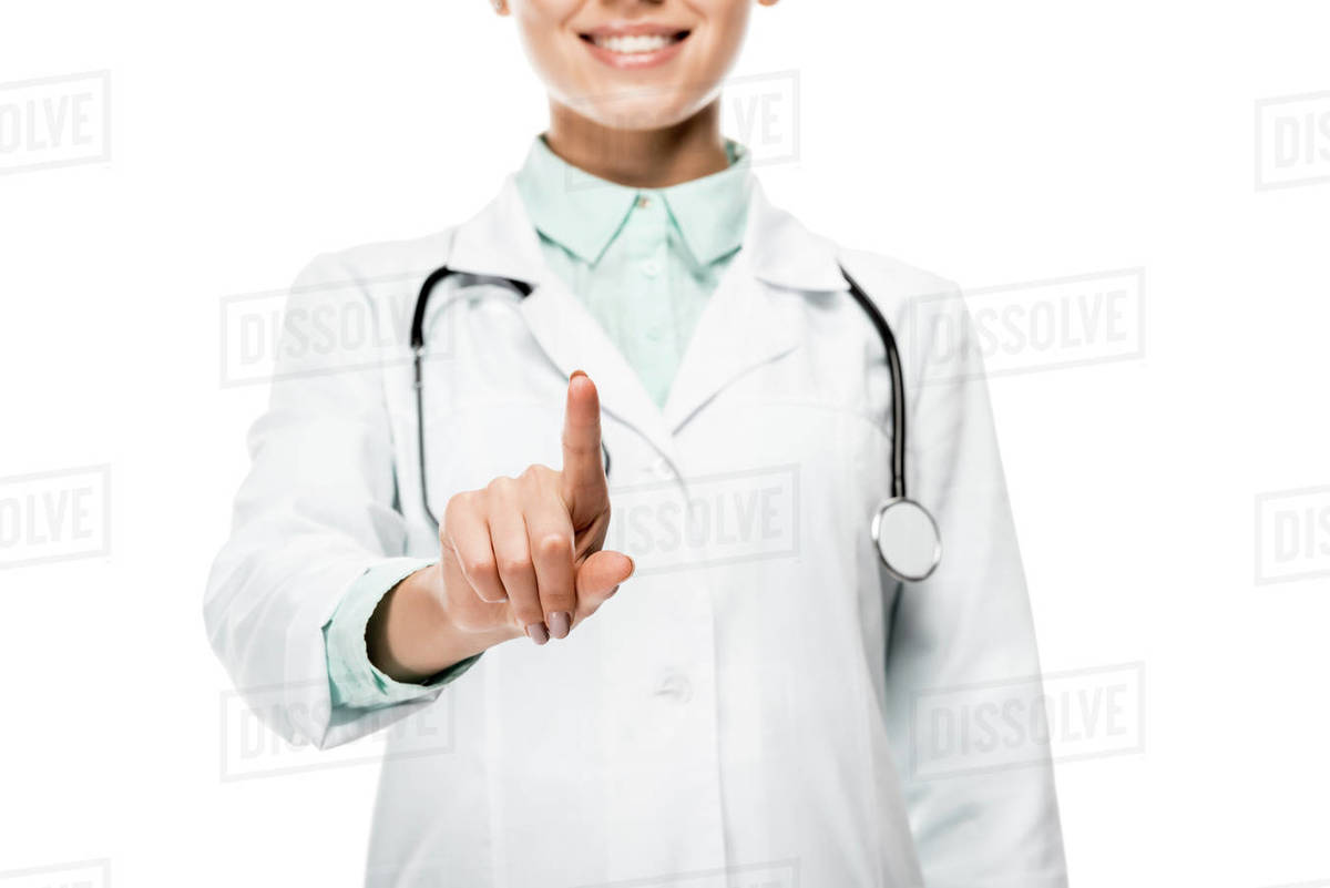 Partial view of smiling female doctor in medical coat pointing at ...