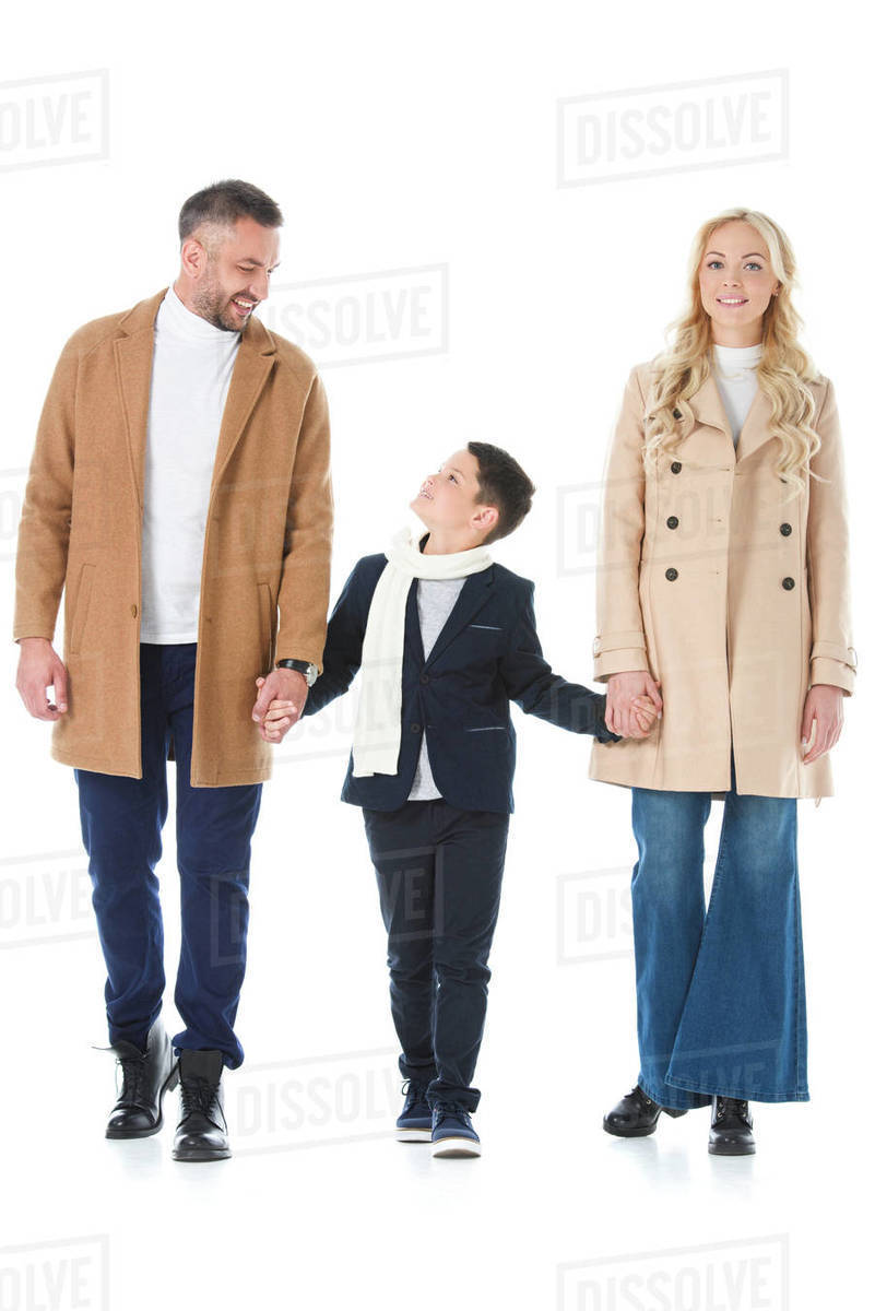 Parents in beige coats holding hands with son, isolated on white ...