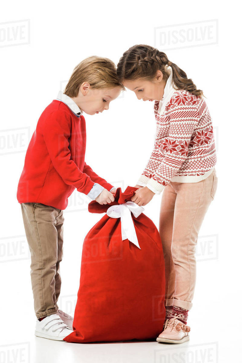 Excited little kids looking at santa gift sack isolated on white ...