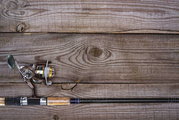 Top view of fishing rod on wooden planks, minimalistic concept ...