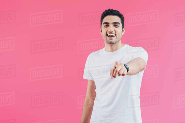 Laughing man pointing on camera isolated on pink - Stock Photo - Dissolve