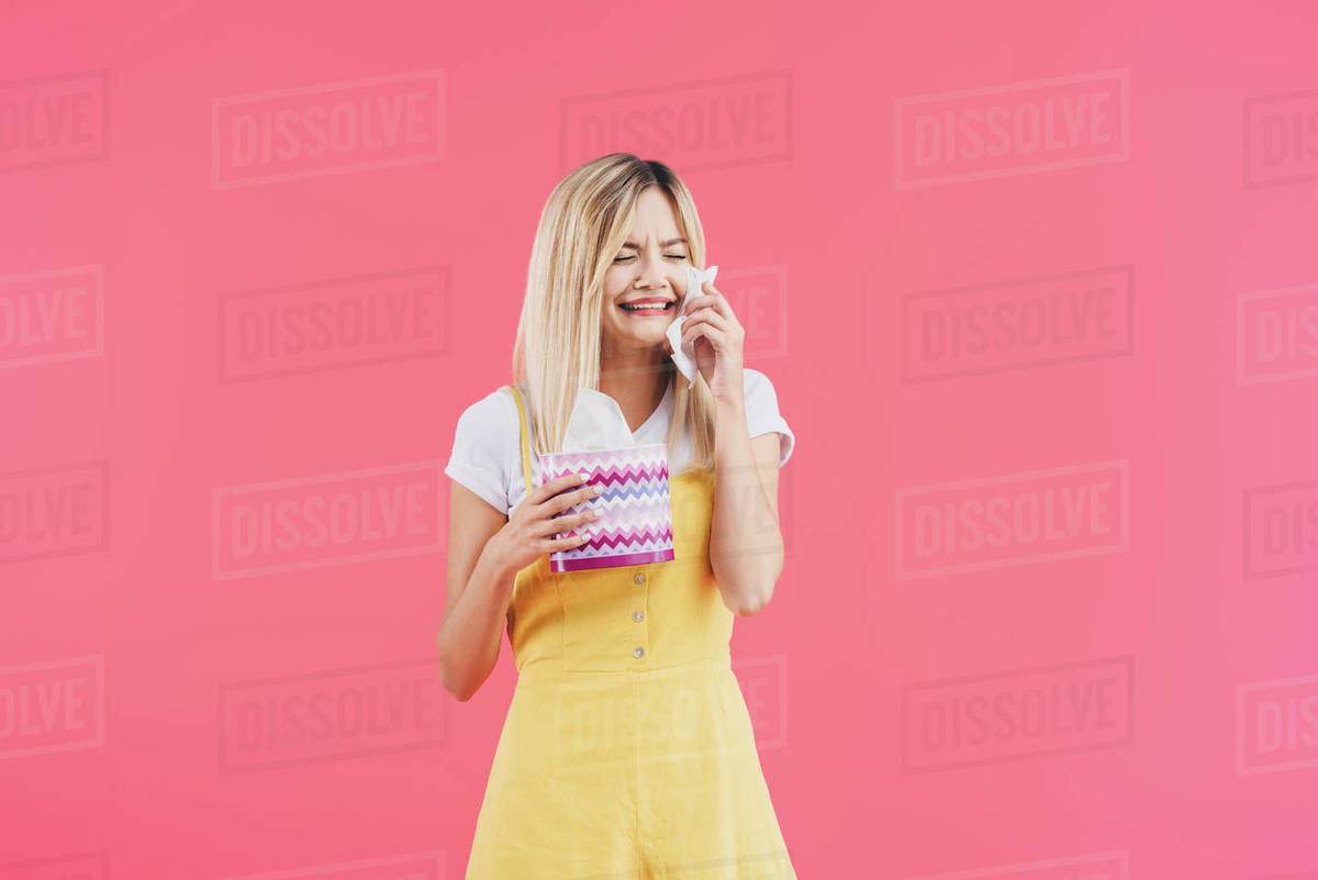 Emotional young woman with tissue box crying and wiping tears isolated ...