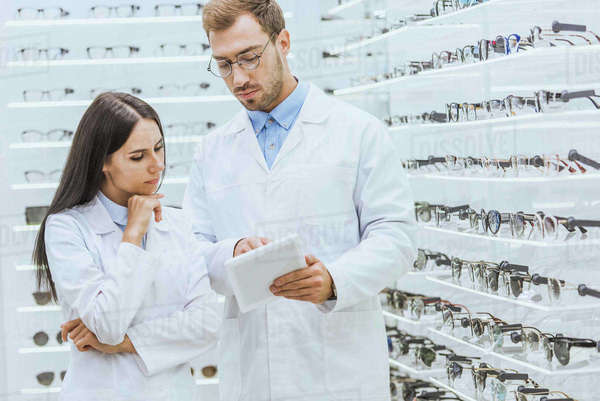 Professional optometrists working and using digital tablet in ...