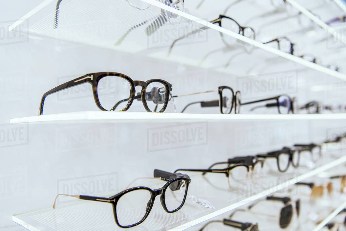 Selective focus of white shelves with trendy glasses in ophthalmic shop ...