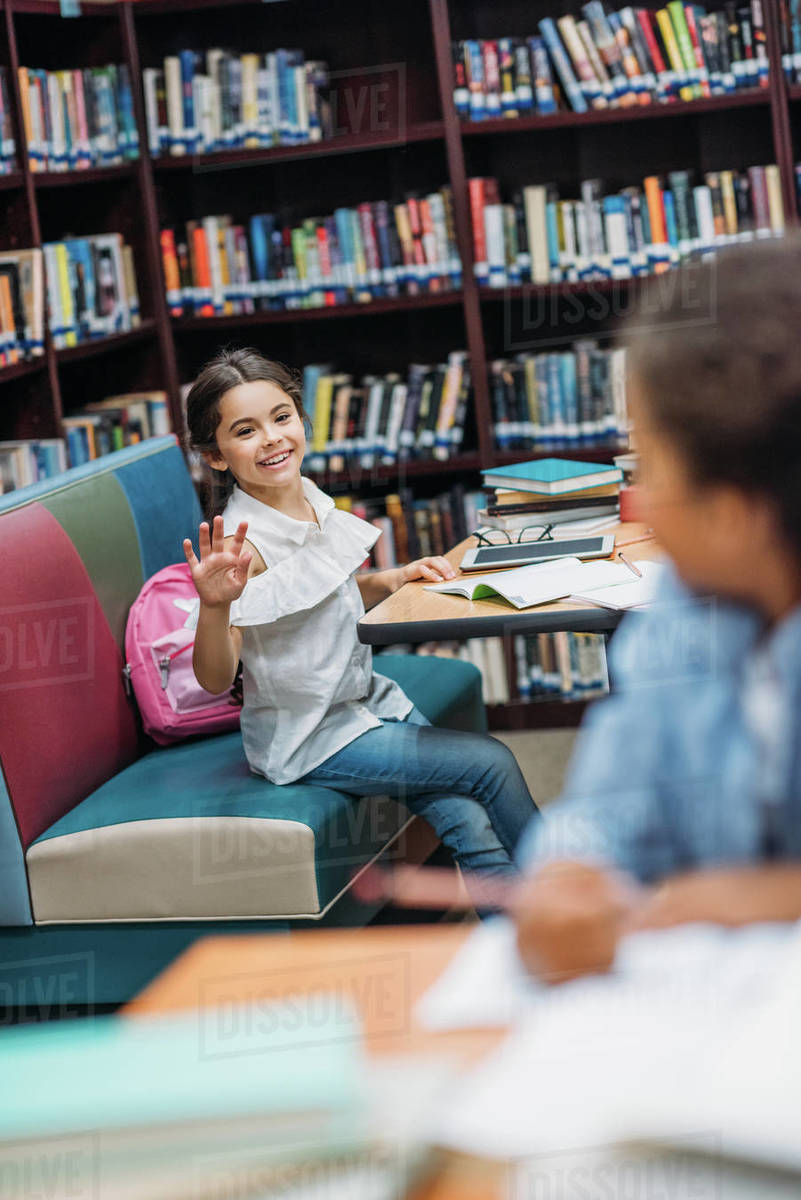 beautiful multiethnic schoolgirls greeting at school library - Royalty ...