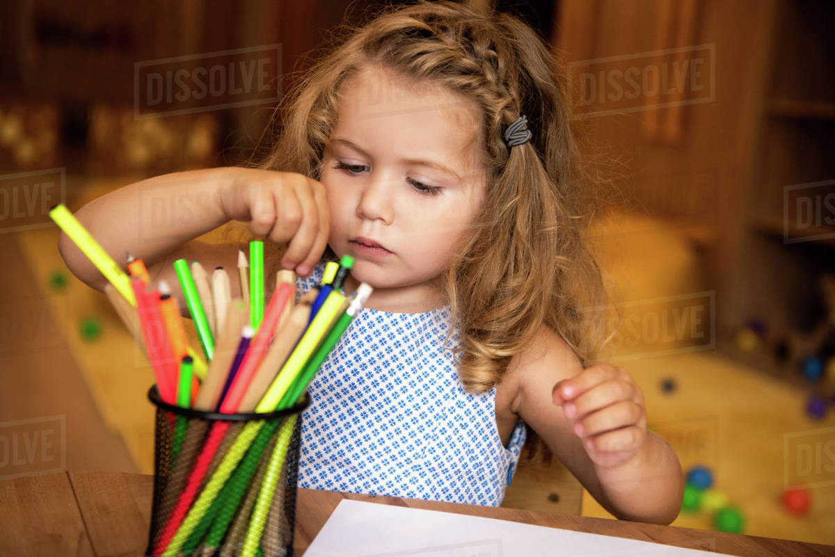 Adorable kid choosing colored felt tip pen for drawing in kindergarten ...