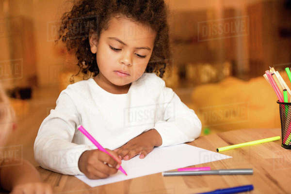 Adorable african american kid drawing with pink felt pen in ...