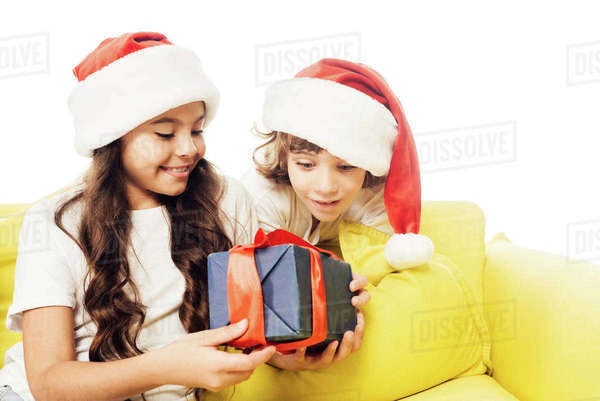 Excited adorable kids in Santa hats looking at present isolated on ...
