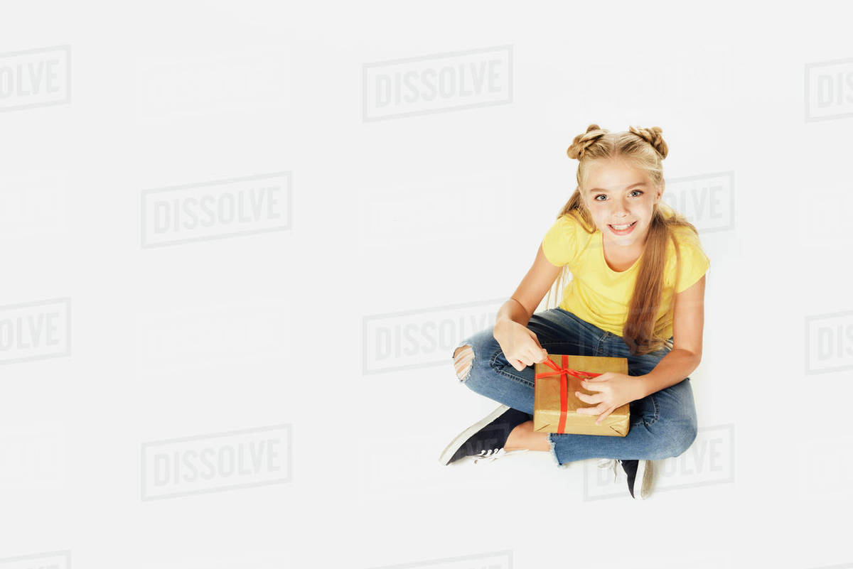 High angle view of beautiful happy child holding present and smiling at ...