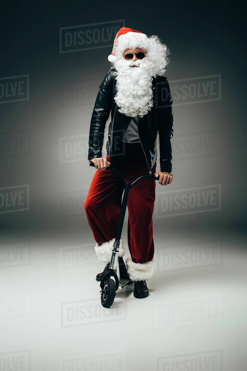 Serious Santa Claus in sunglasses and leather jacket standing with kick ...
