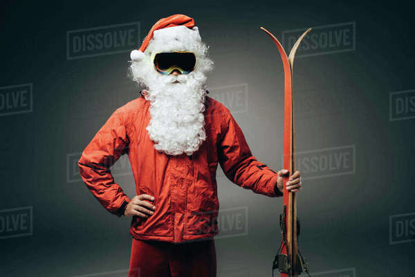 Confident Santa Claus in ski mask and windbreaker standing with hand on ...