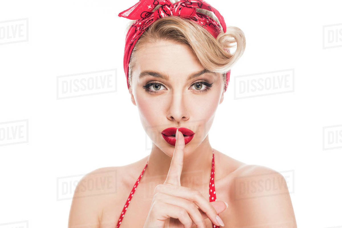 portrait of attractive pin up woman doing shush gesture and looking at ...