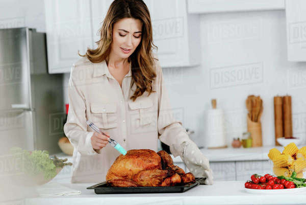Attractive happy woman cooking thanksgiving turkey at kitchen - Stock ...