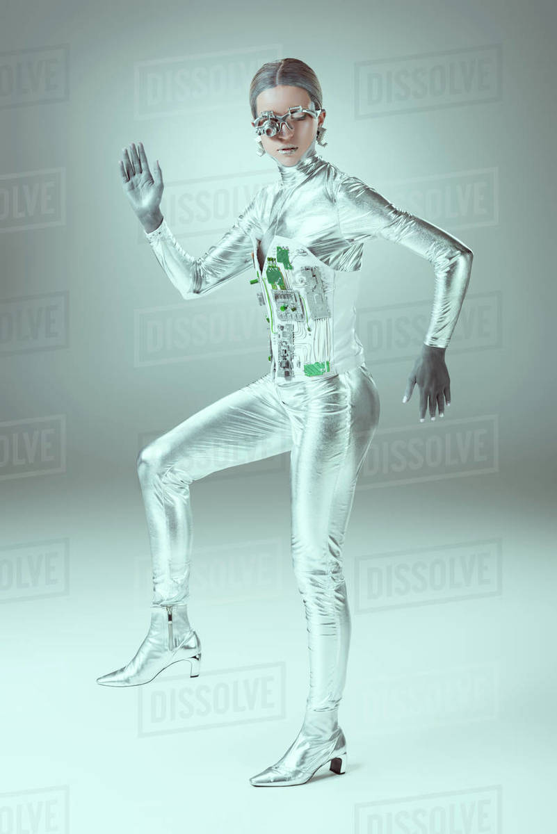 Full length view of futuristic cyborg walking and looking at camera on ...