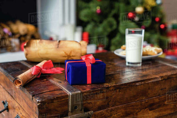 Close-up view of parchment, gift box and glass of milk with cookies on ...