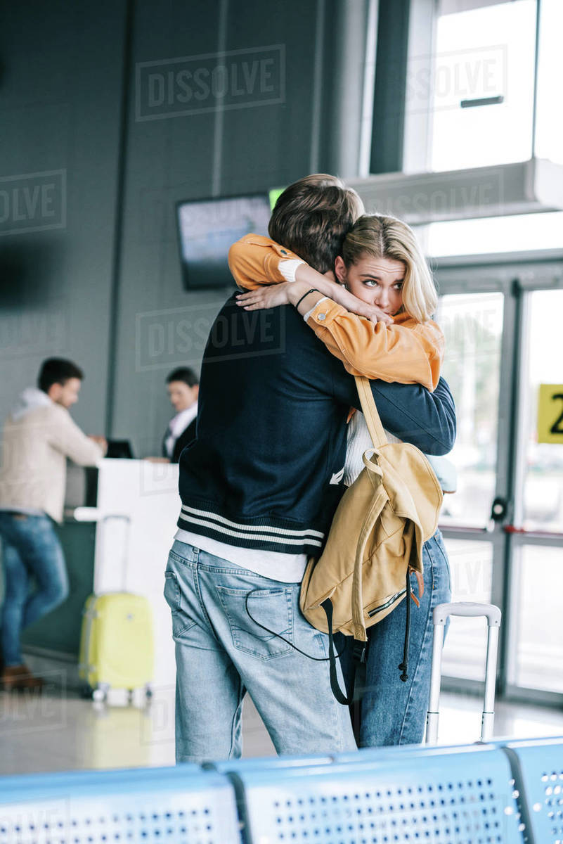 Emotional young couple hugging in airport terminal - Royalty-free Stock ...